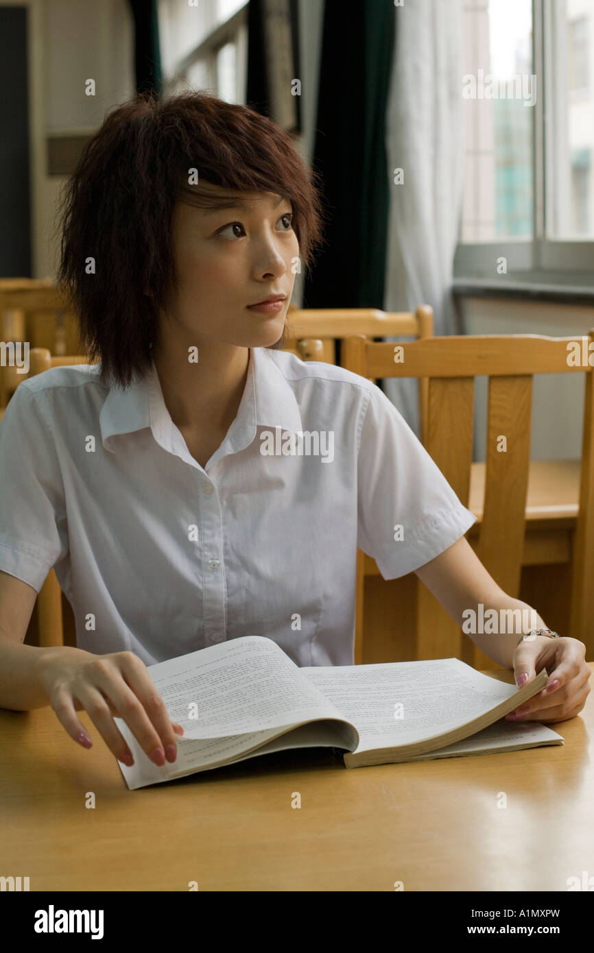 Young woman browsing through books Stock Photo - Alamy