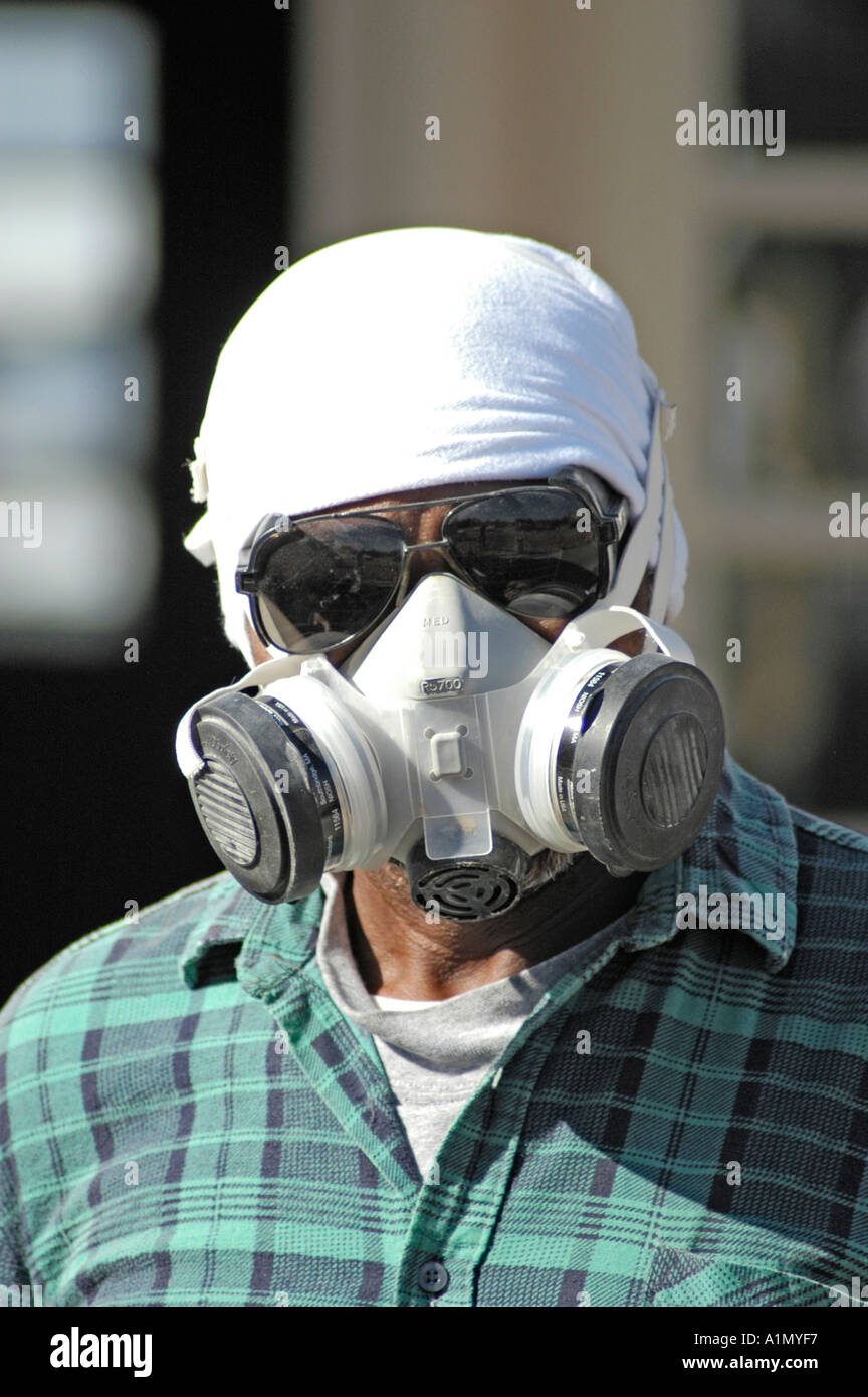 Man wearing safety mask and breather working on rebuilding commercial ...