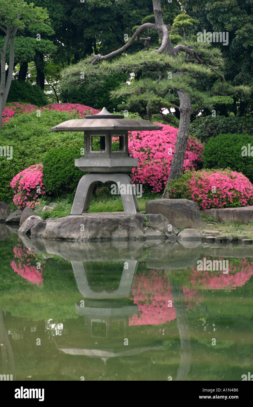Stone lantern in a colourful traditional Japanese garden reflected in a ...