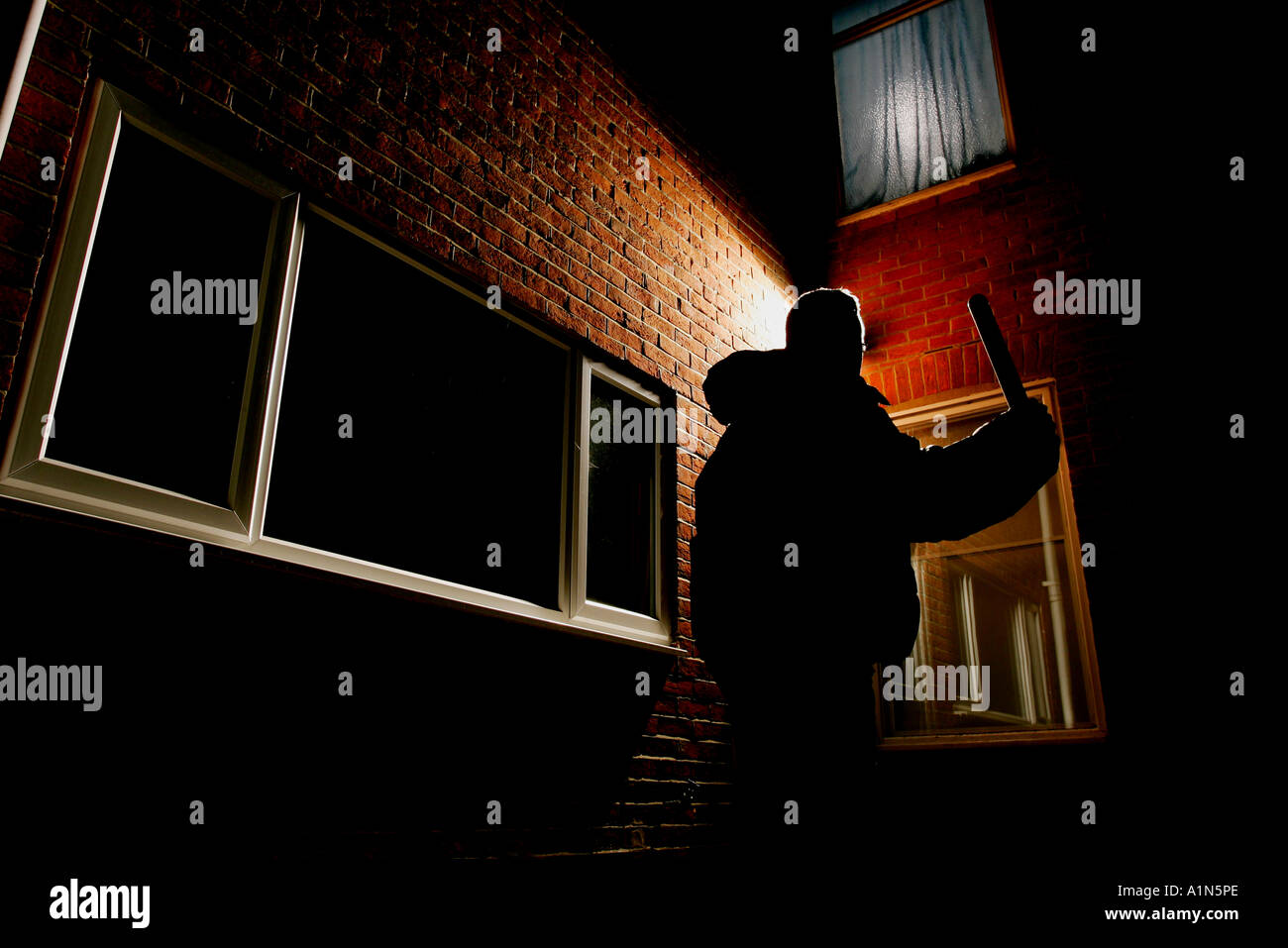 AN INTRUDER APPROCHES BUILDING WITH A WEAPON Stock Photo - Alamy