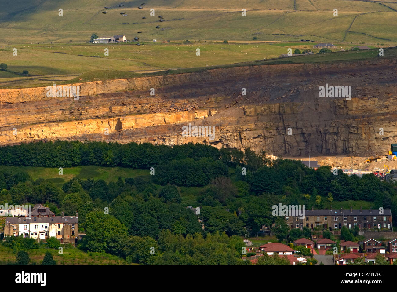 Quarry cut into hillside with houses in foreground in ramsbottom ...