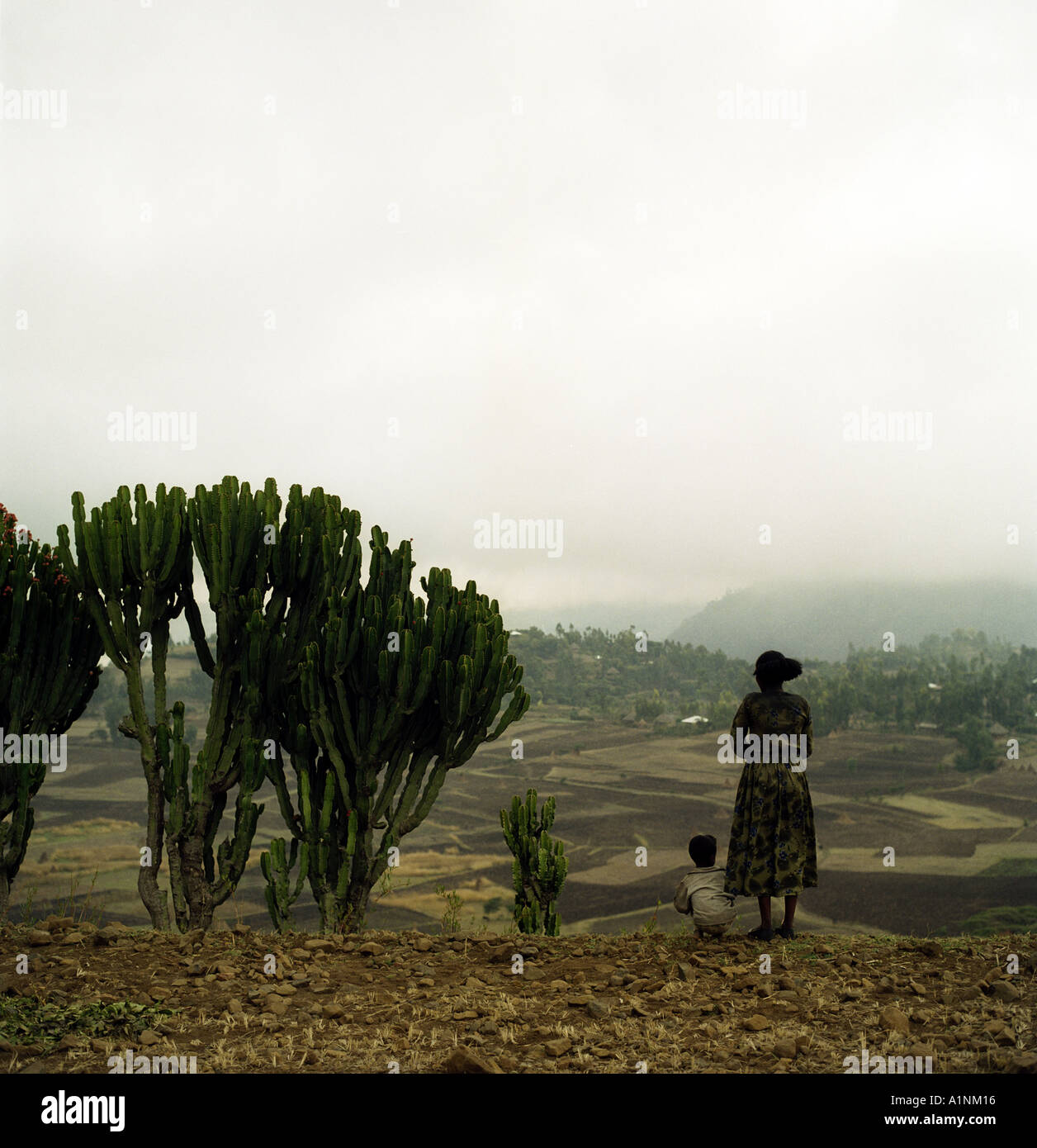 A mother and child stand on a hillside overlooking the site of ex site ...