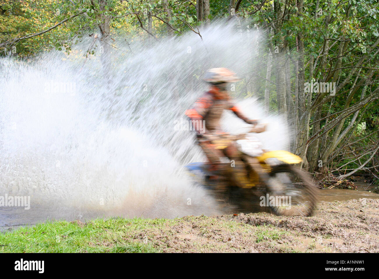 Enduro motorcyclist in Water Splash Stock Photo - Alamy
