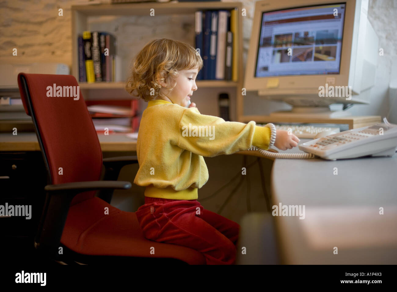 Young child on office telephone Stock Photo - Alamy
