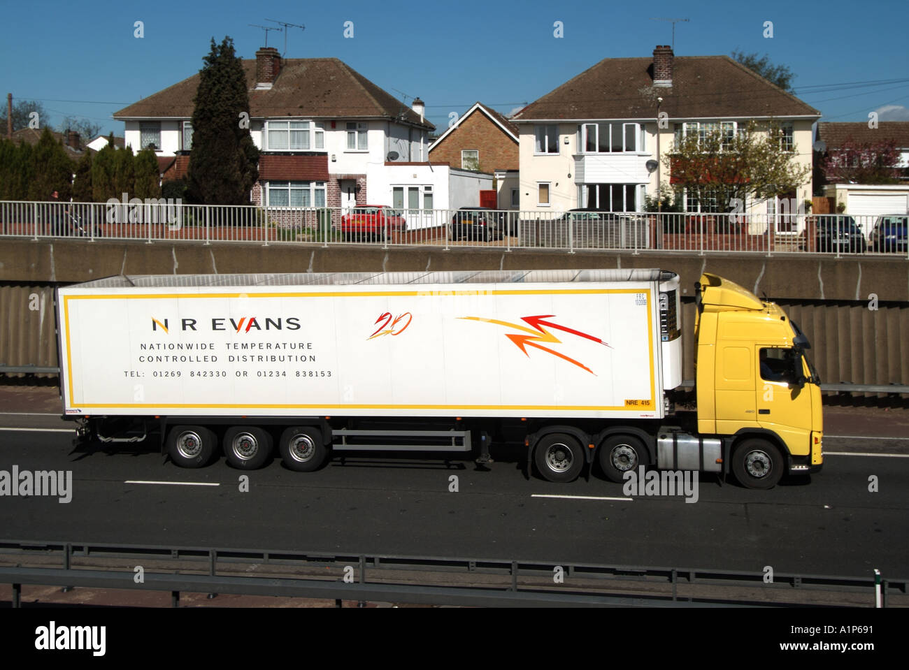 Lorry on dual carriageway trunk road in cutting adjacent residential ...