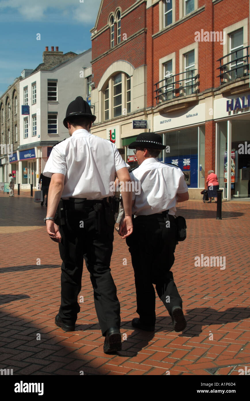 Two police officers in high street shopping area Stock Photo - Alamy