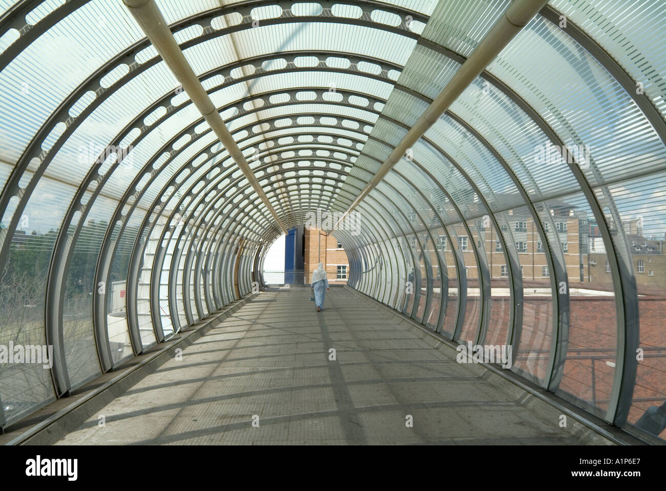 Pedestrian footbridge inside translucent steel framed tubular tunnel ...