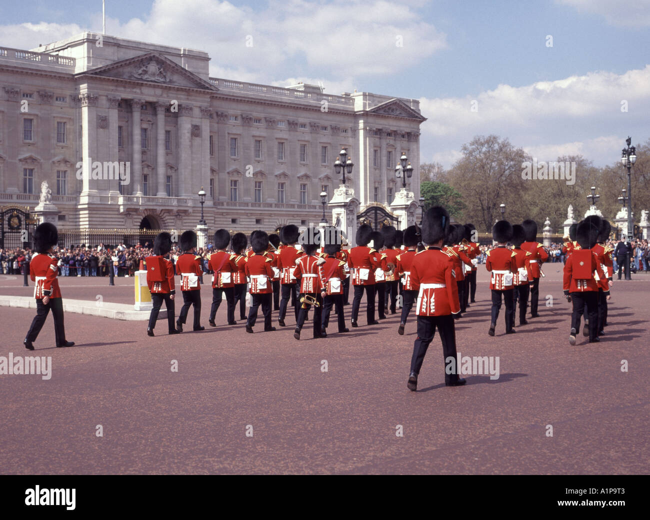 Tourists at changing guard ceremony back view men of British guards ...
