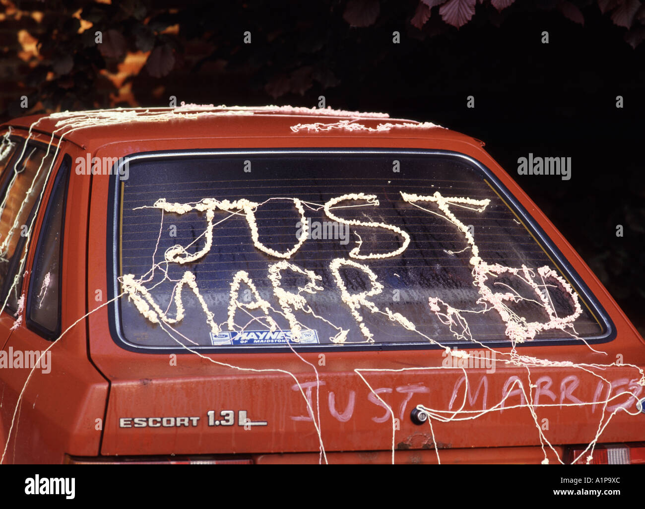 Just Married sprayed onto rear window of car parked outside wedding ...