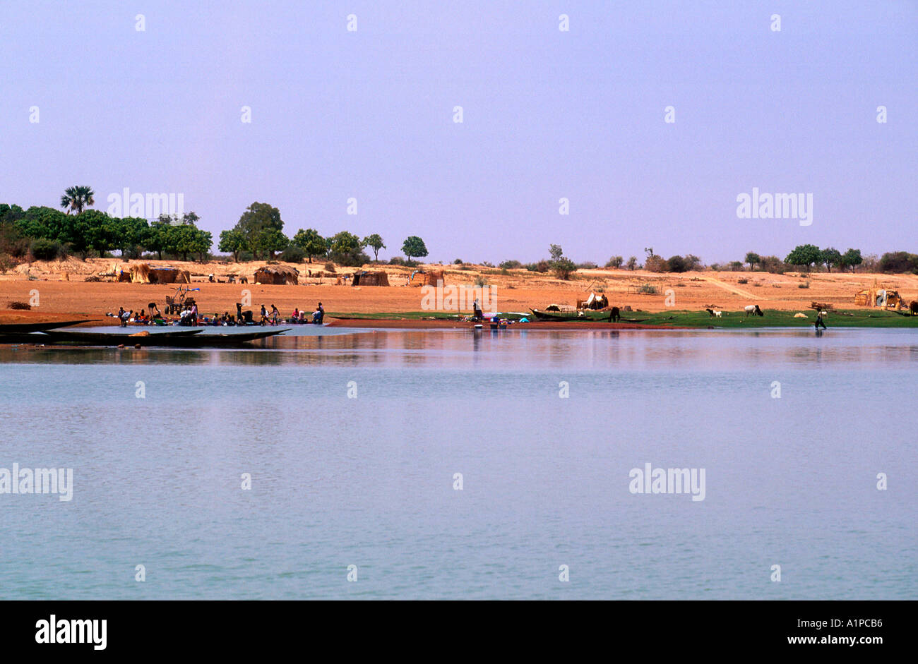Boats line the river bank while people wash in Niger River near ...