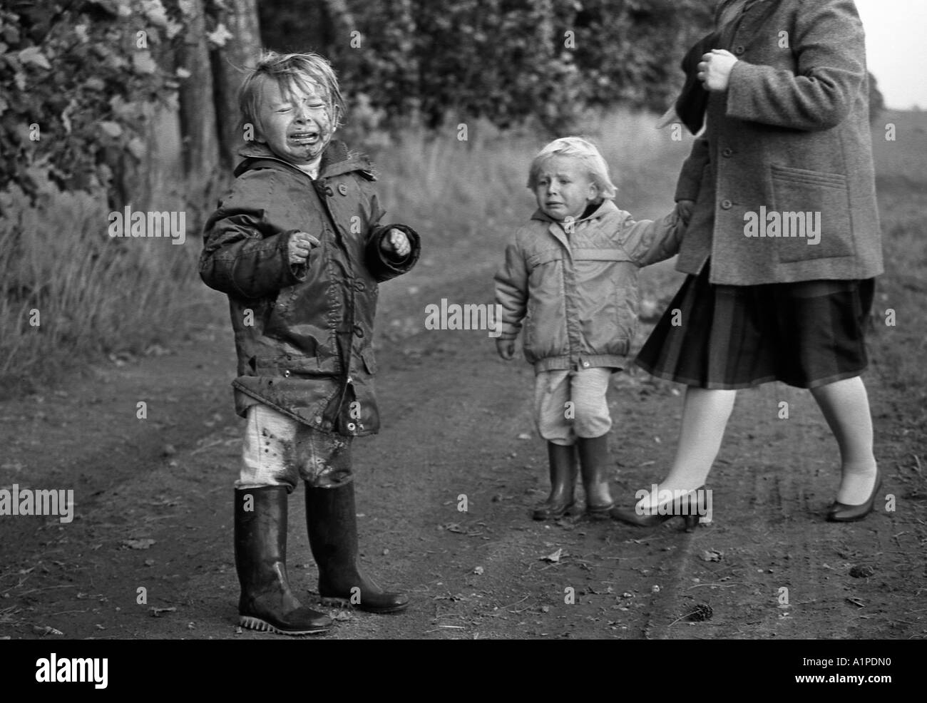 Young boy crying after falling in puddle and covered in mud Stock Photo ...