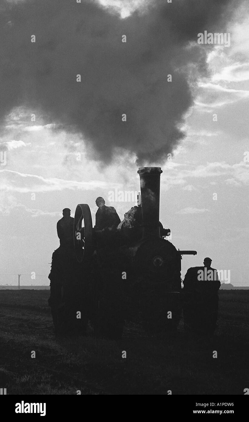 Group of men in silhouette on a traction engine making smoke Stock ...
