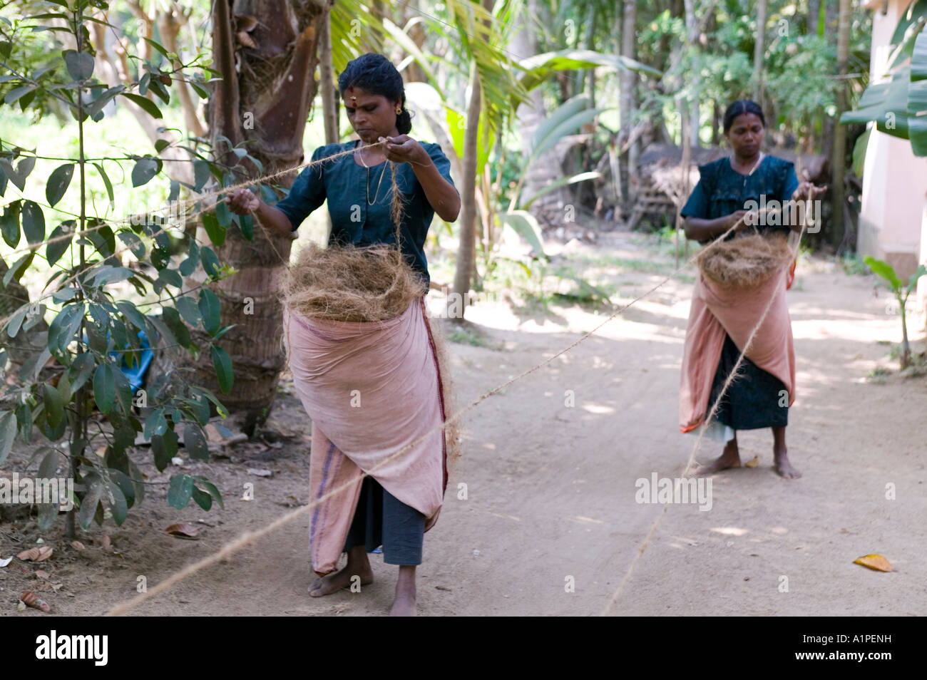 Two women spin jute to make rope in Kerala India Stock Photo - Alamy