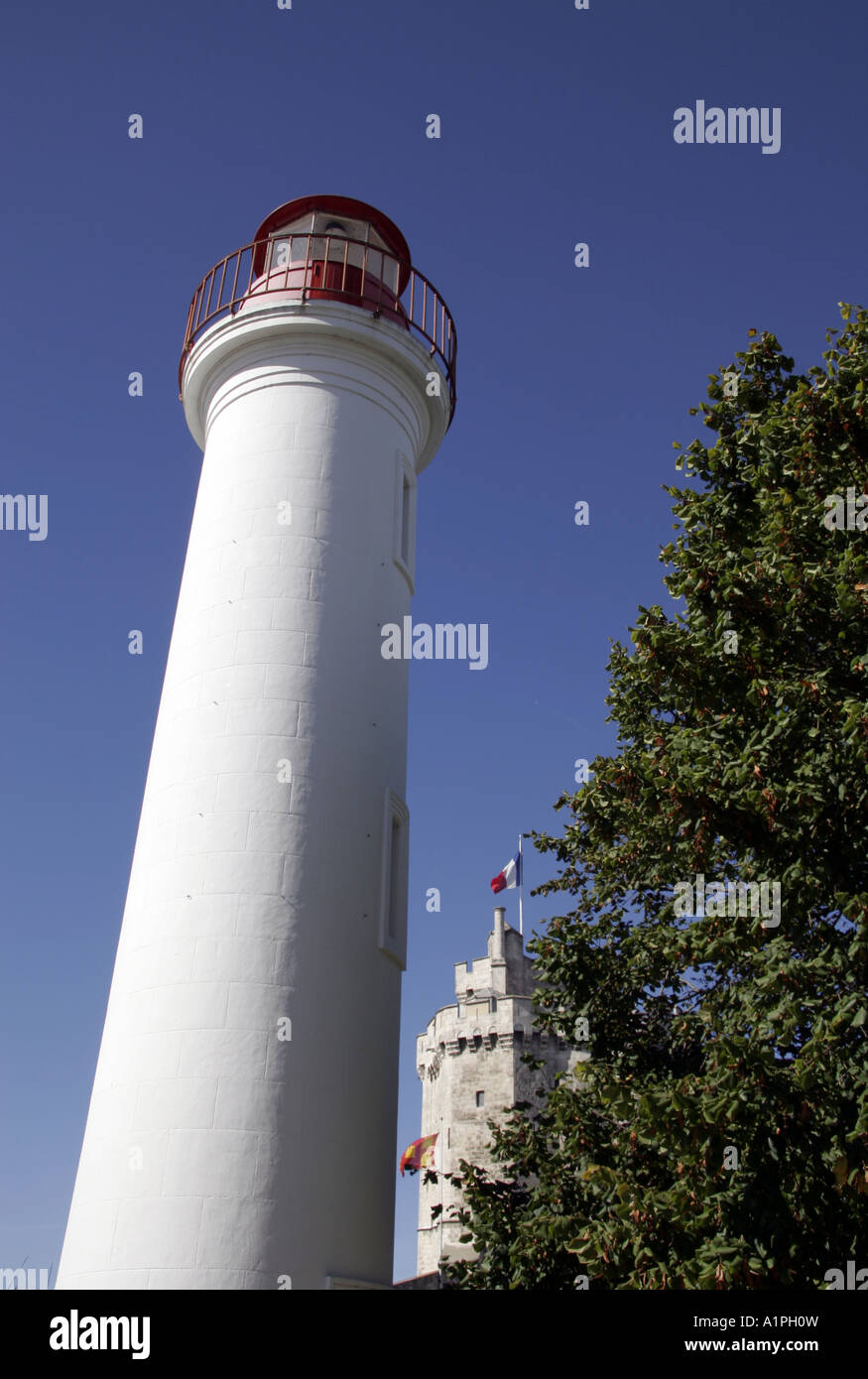 Lighthouse in the old port of La Rochelle France, with St. Nicholas ...