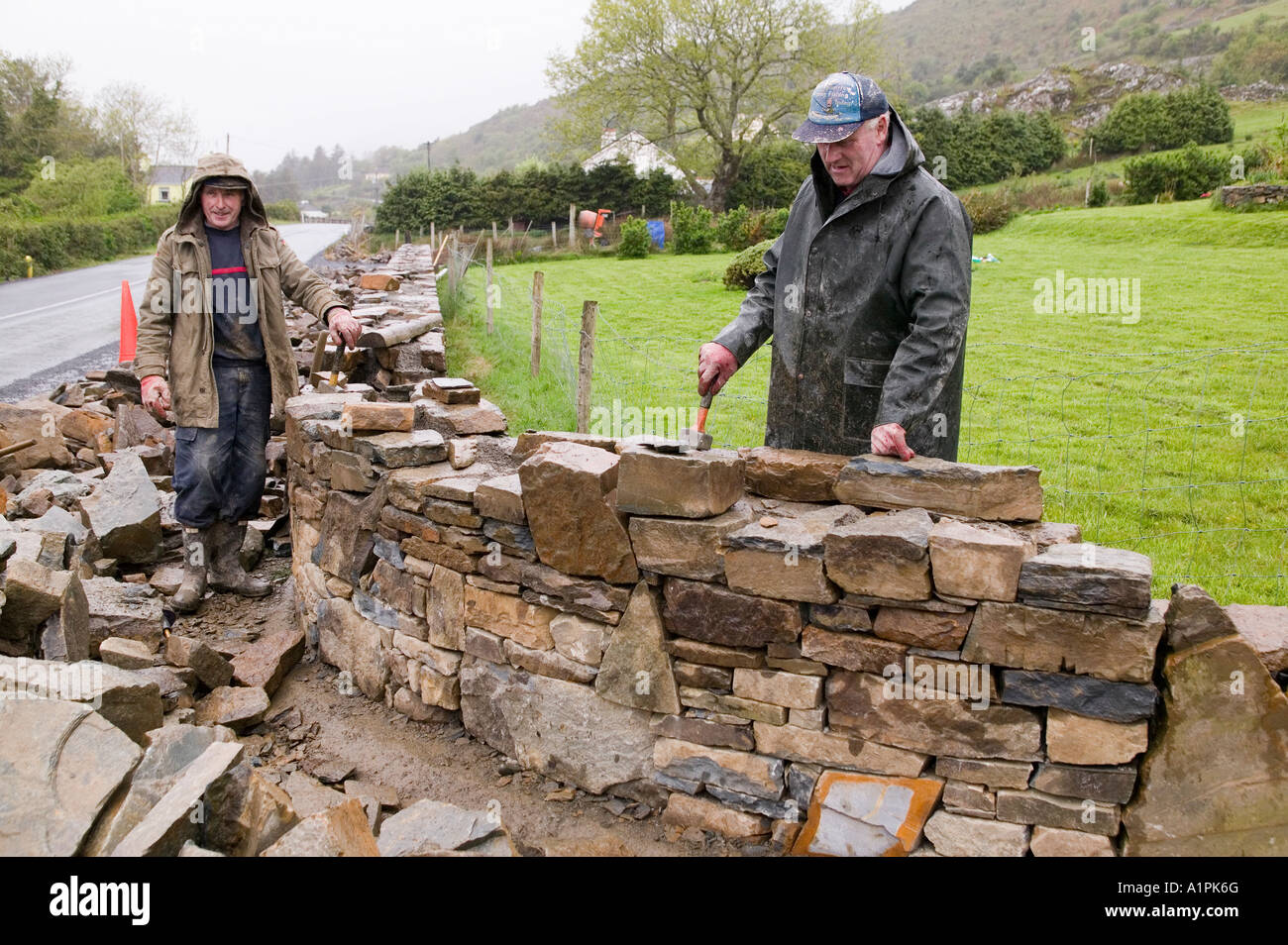 Two men building a rock wall by hand in West Ireland Stock Photo - Alamy