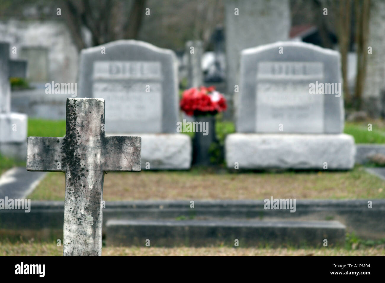 Stone cross in front of tombstones Stock Photo - Alamy