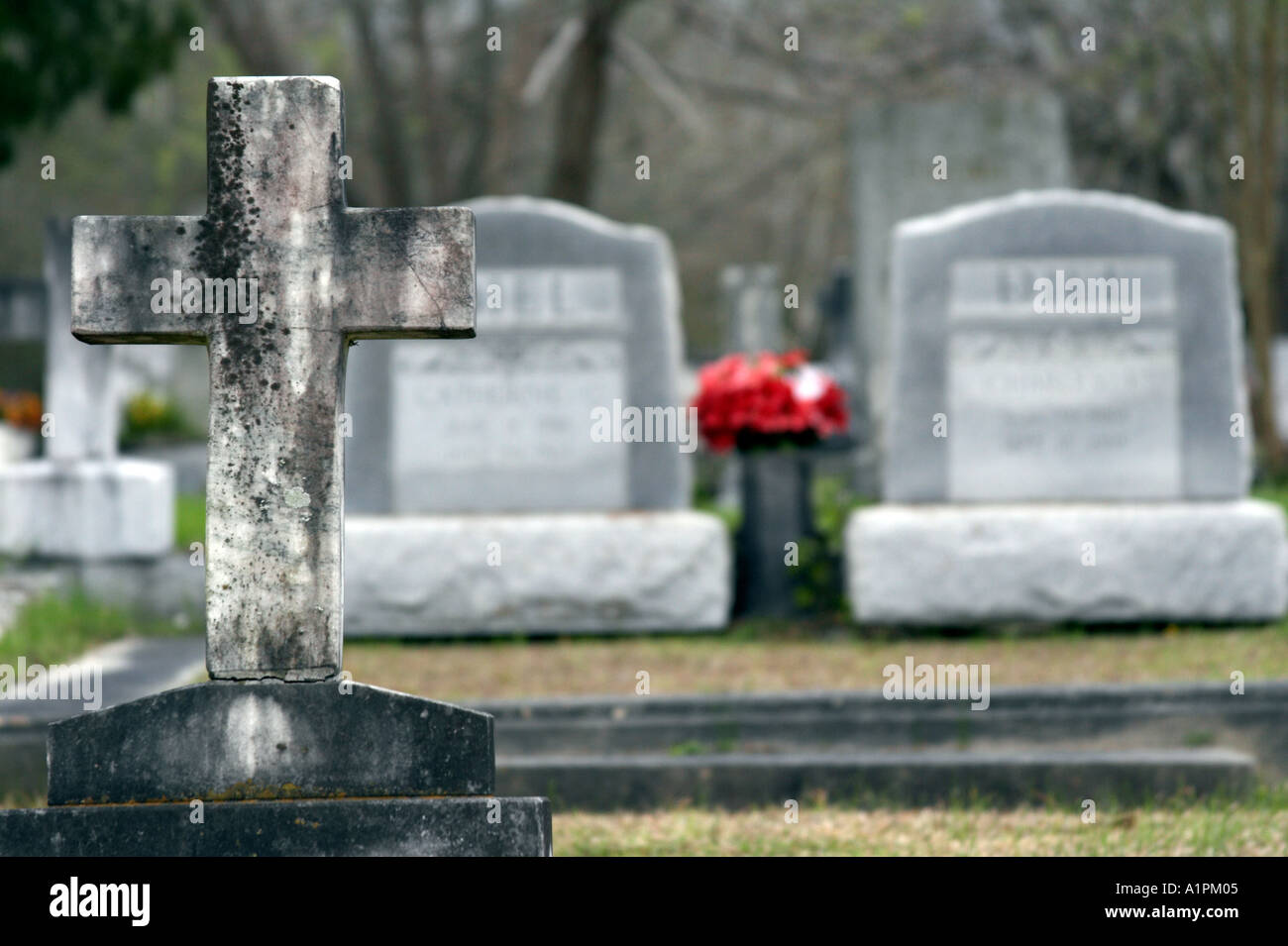 Stone cross in front of tombstones Stock Photo - Alamy