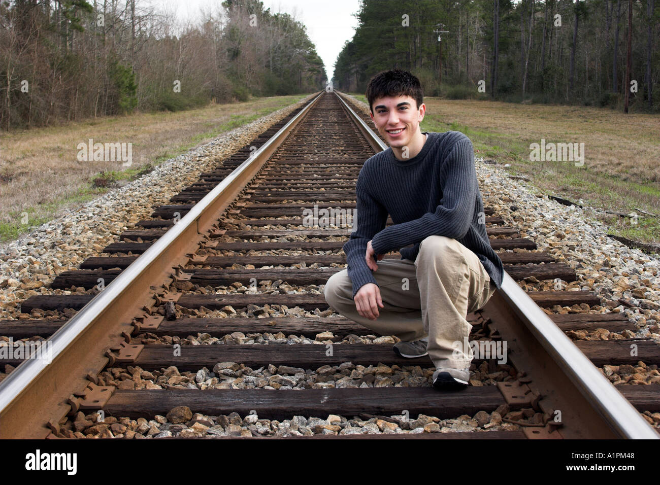 Young man on railroad tracks Stock Photo - Alamy