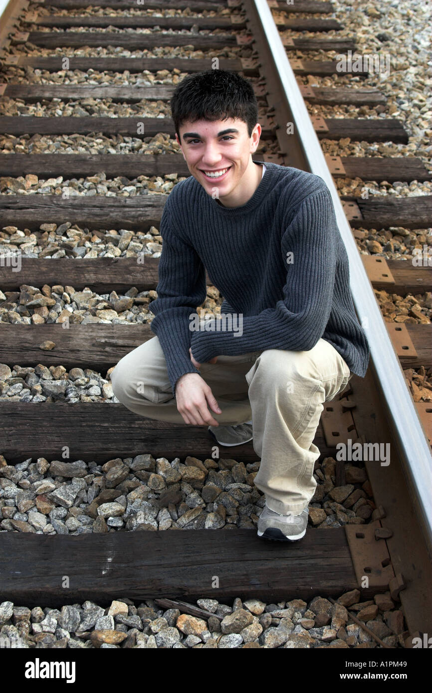 Young man on railroad tracks Stock Photo - Alamy