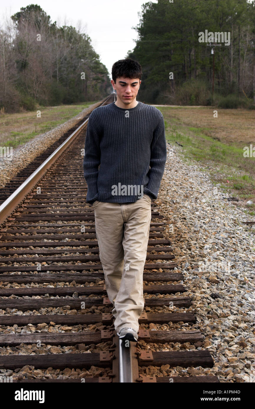 Young man on railroad tracks Stock Photo - Alamy