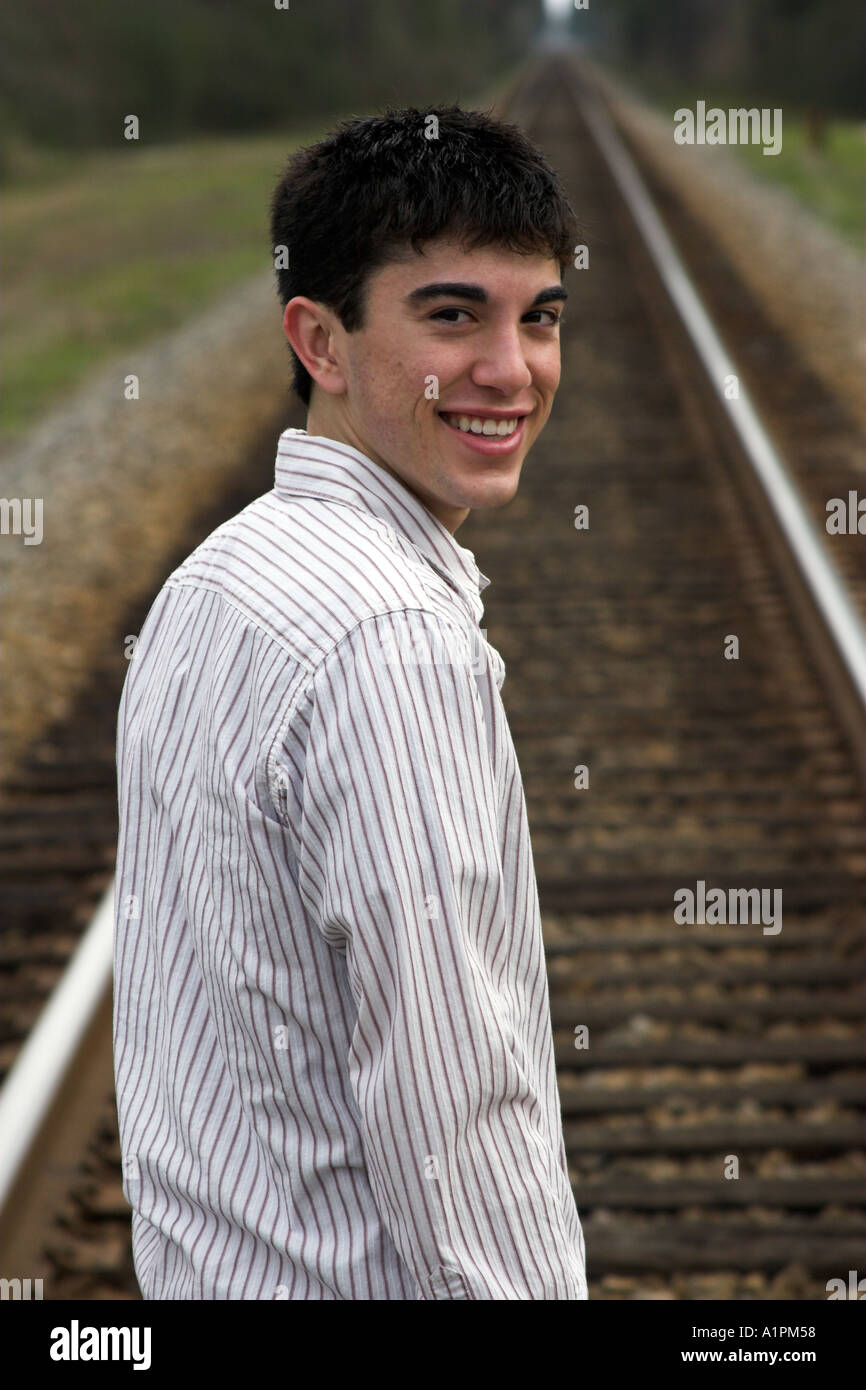 Young man on railroad tracks Stock Photo - Alamy