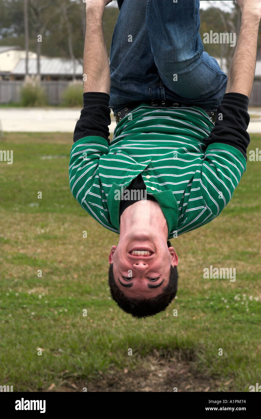 Young man hanging upside down Stock Photo - Alamy