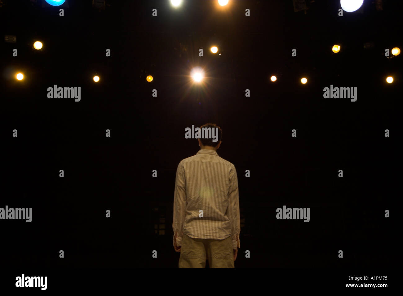 Young man on stage in front of stagelights Stock Photo - Alamy