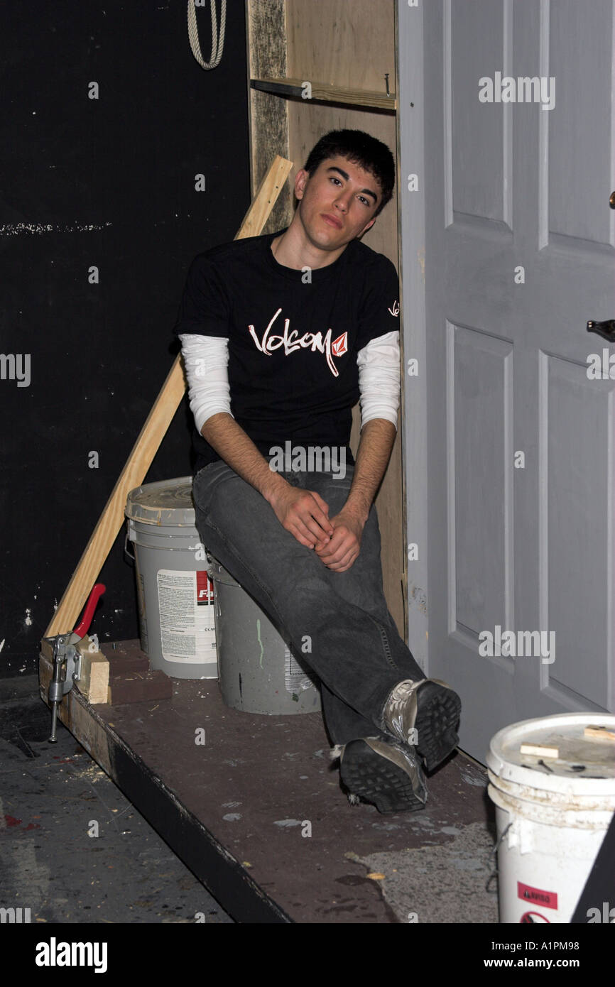Young man sitting on props backstage in a theatre Stock Photo - Alamy