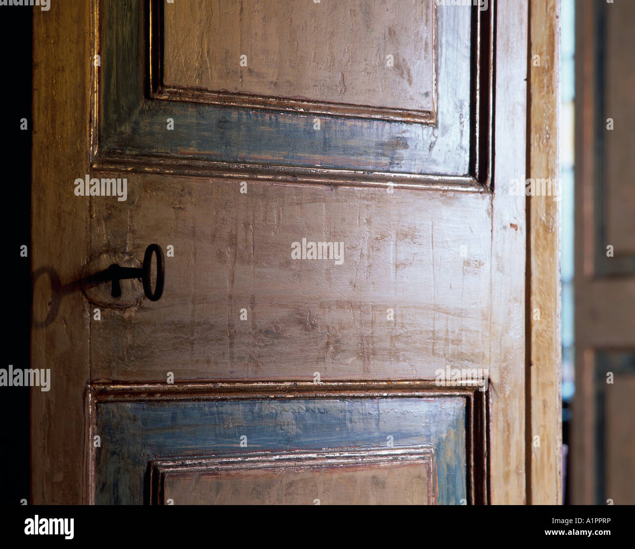 View of a key inserted into a keyhole of a wooden door Stock Photo - Alamy