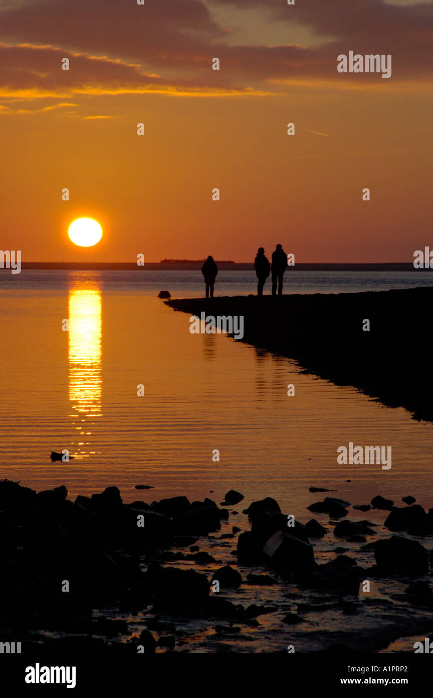 Figures silhouetted by a sunset Stock Photo - Alamy