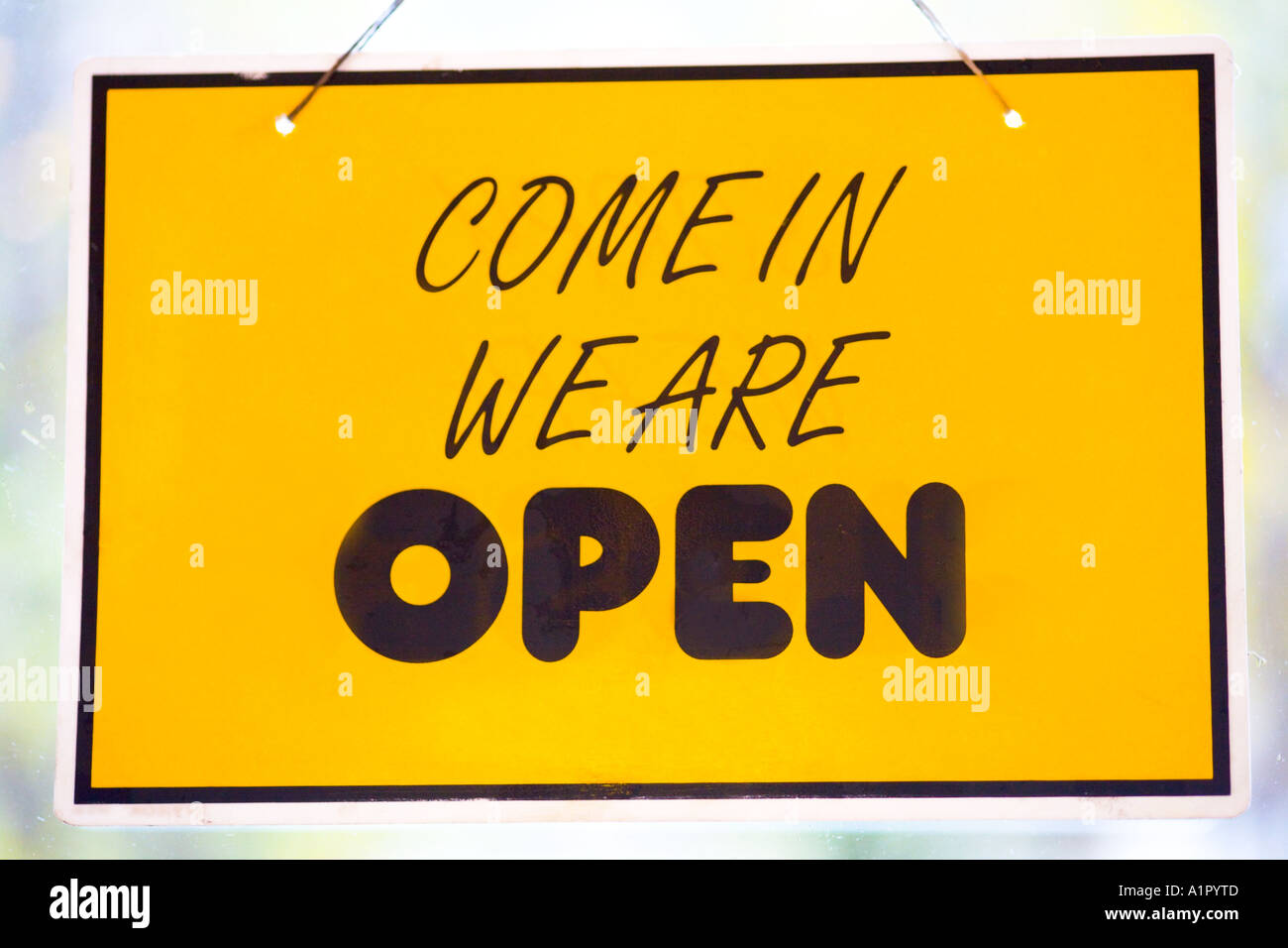 A yellow door sign stating we are open Stock Photo - Alamy