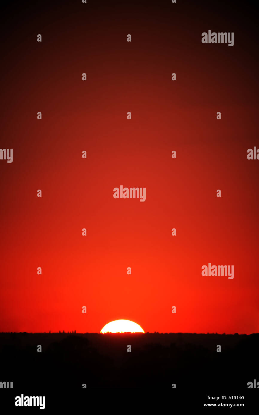 Sunset. Sun setting below the horizon line Stock Photo - Alamy