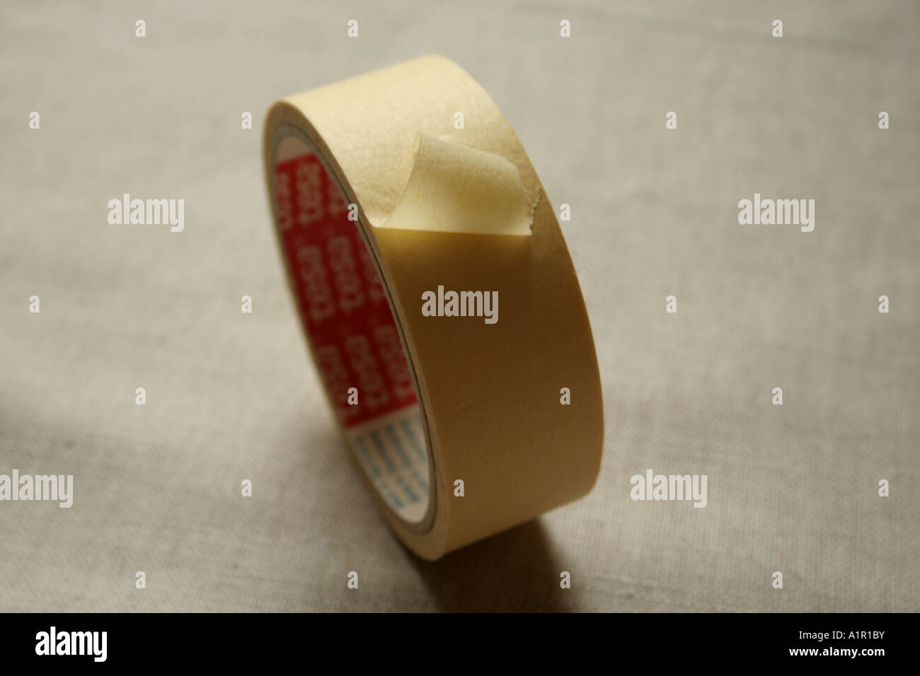 Close-up of a roll of masking tape with a piece partially peeled ...