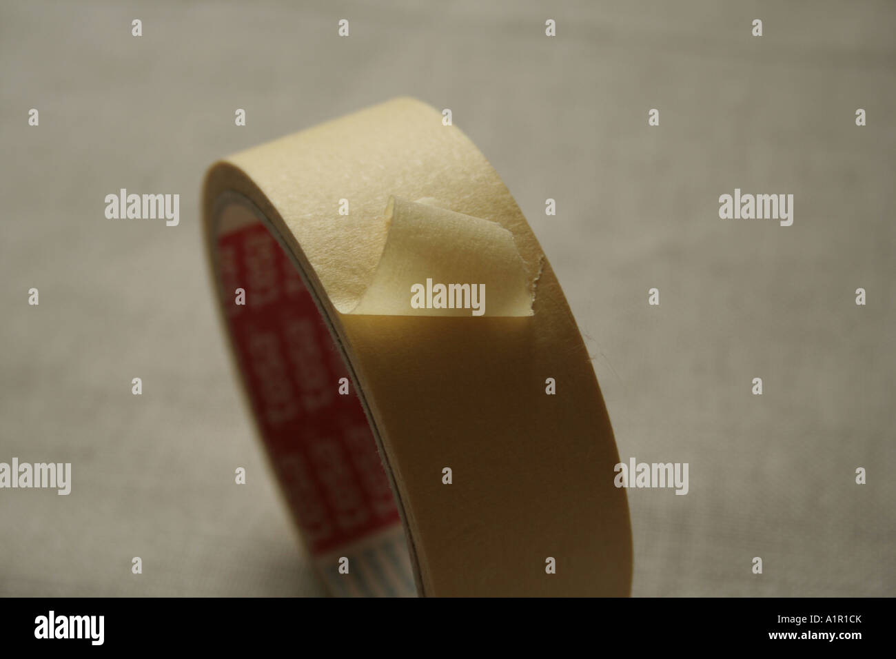 Close-up of a roll of masking tape with a piece partially peeled ...