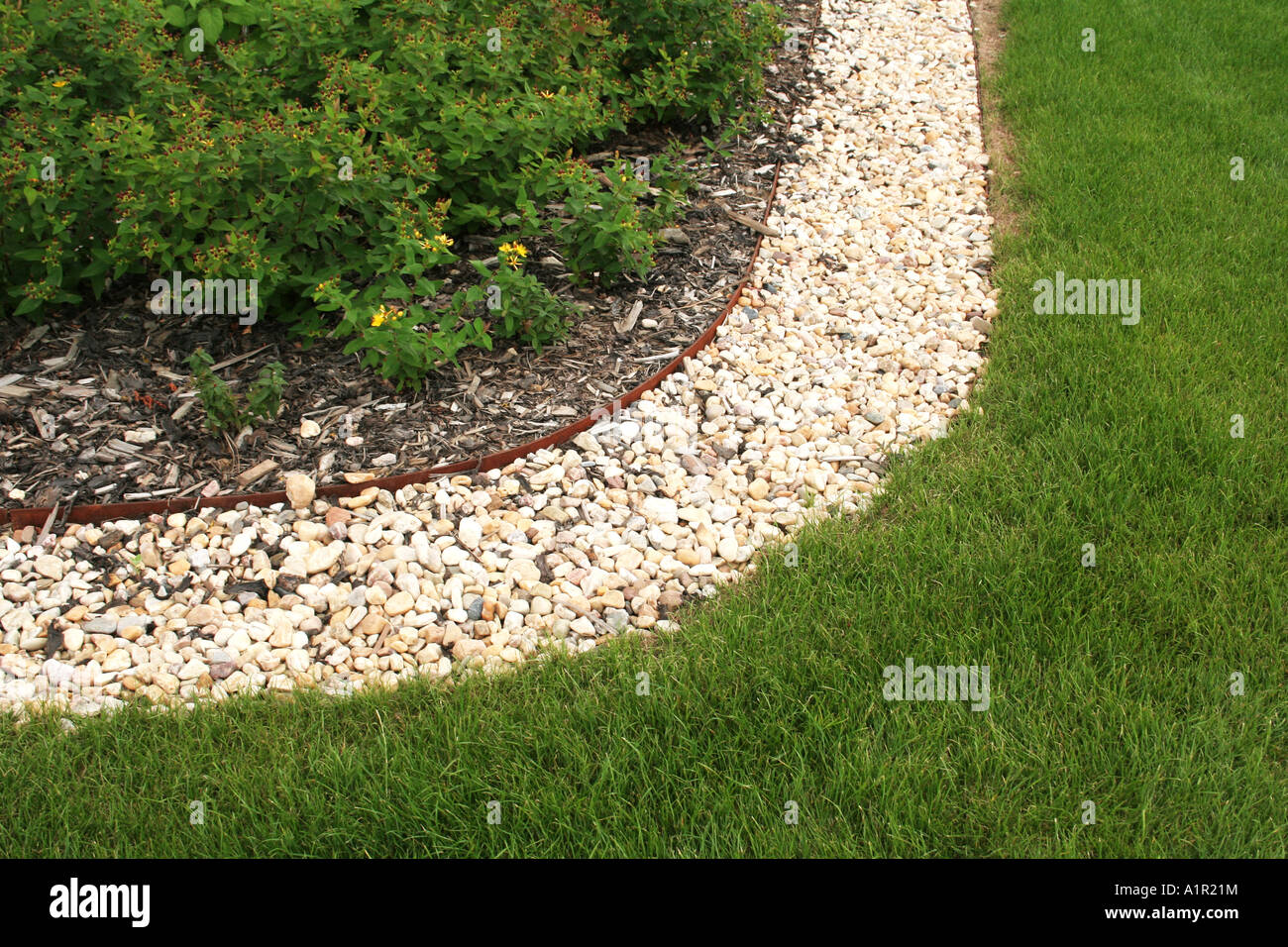 Garden landscaping with stone pathway, mulch, and green grass ...