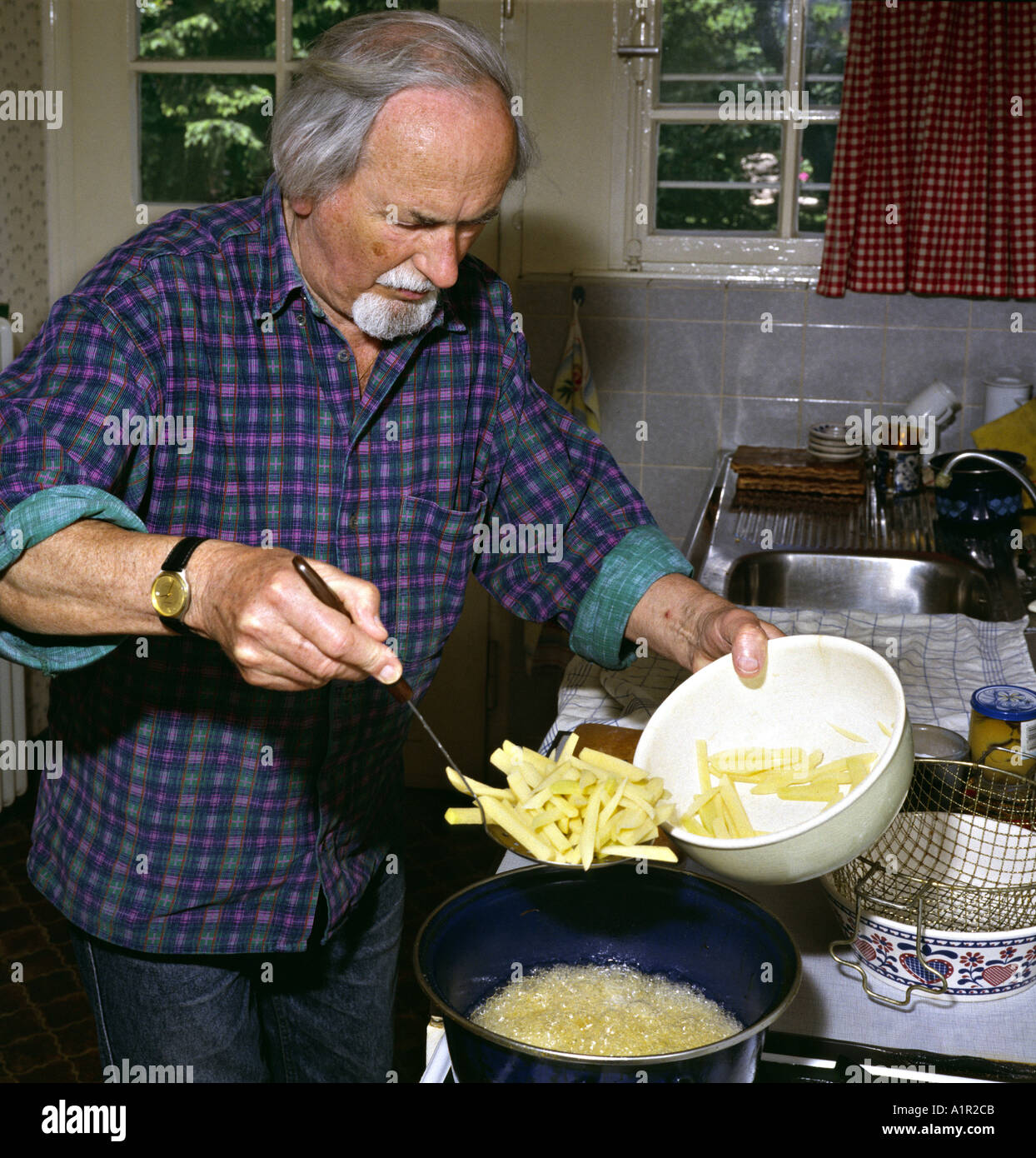 pensioner by cooking making French fries MR Stock Photo - Alamy