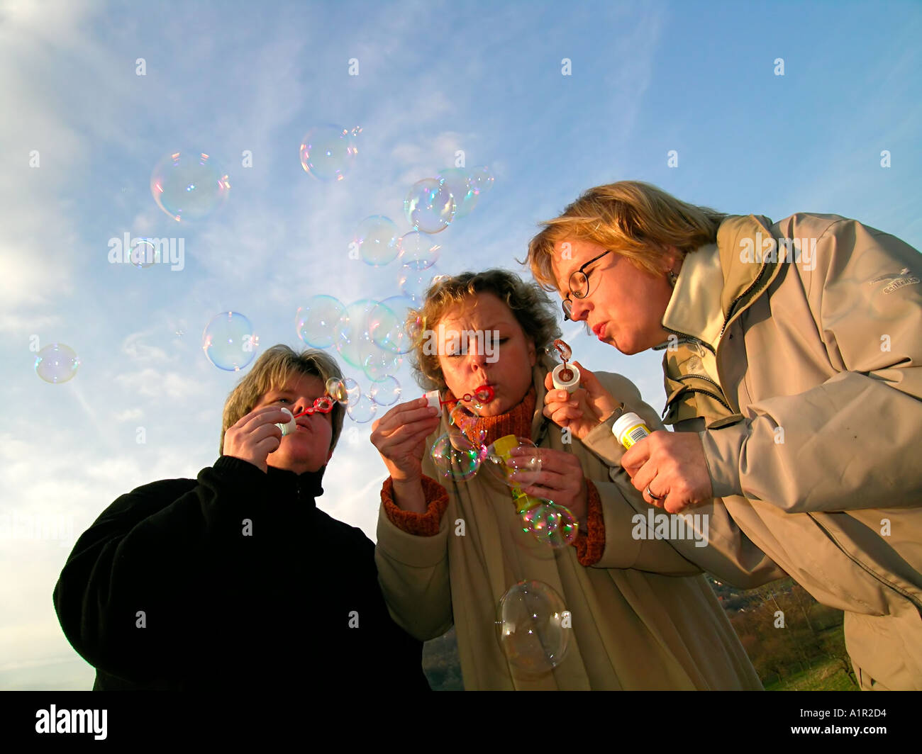 three women making soap bubbles MR Stock Photo - Alamy