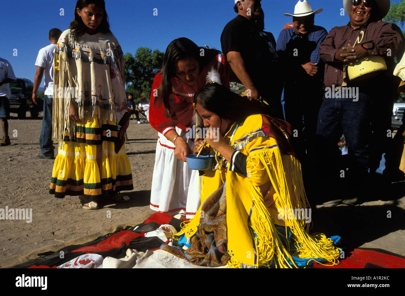 An Apache girl drinks water through a straw at her Sunrise Dance on the ...