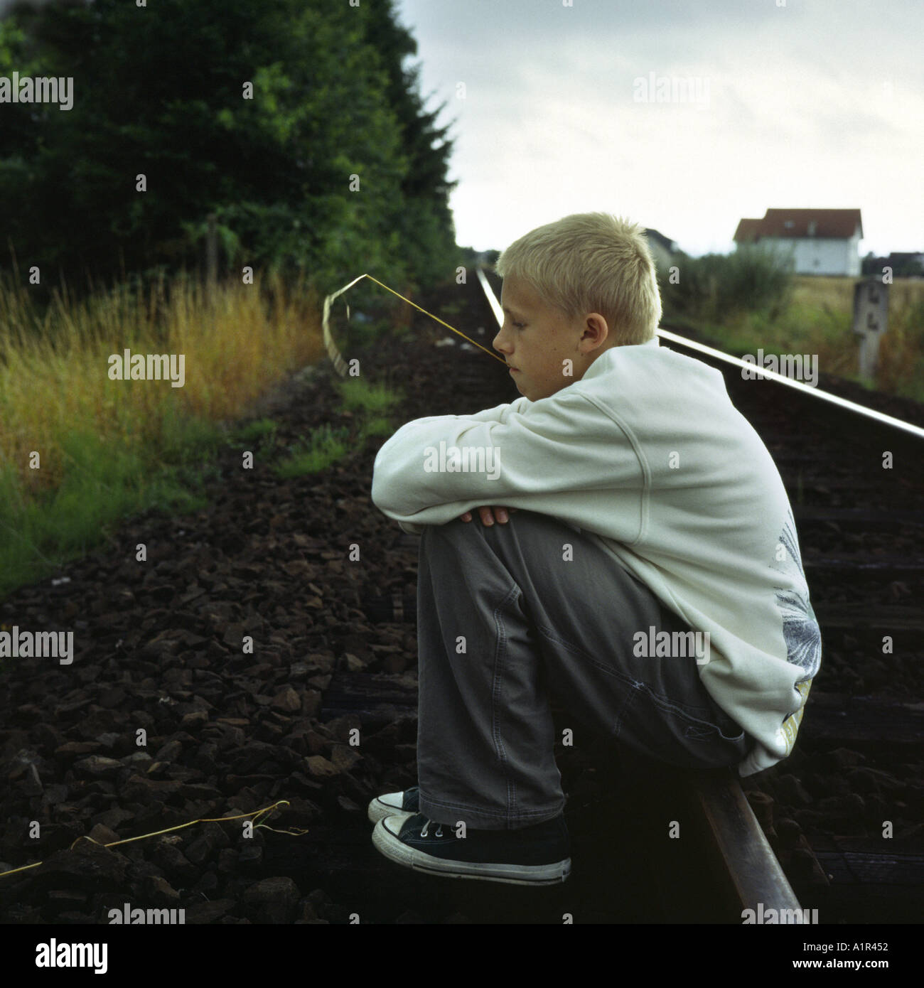 fair haired boy sitting on railway MR Stock Photo - Alamy