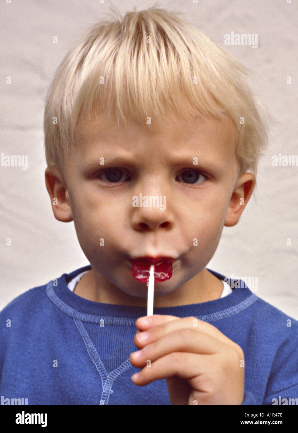 fair haired boy sucking a lollipop MR Stock Photo - Alamy