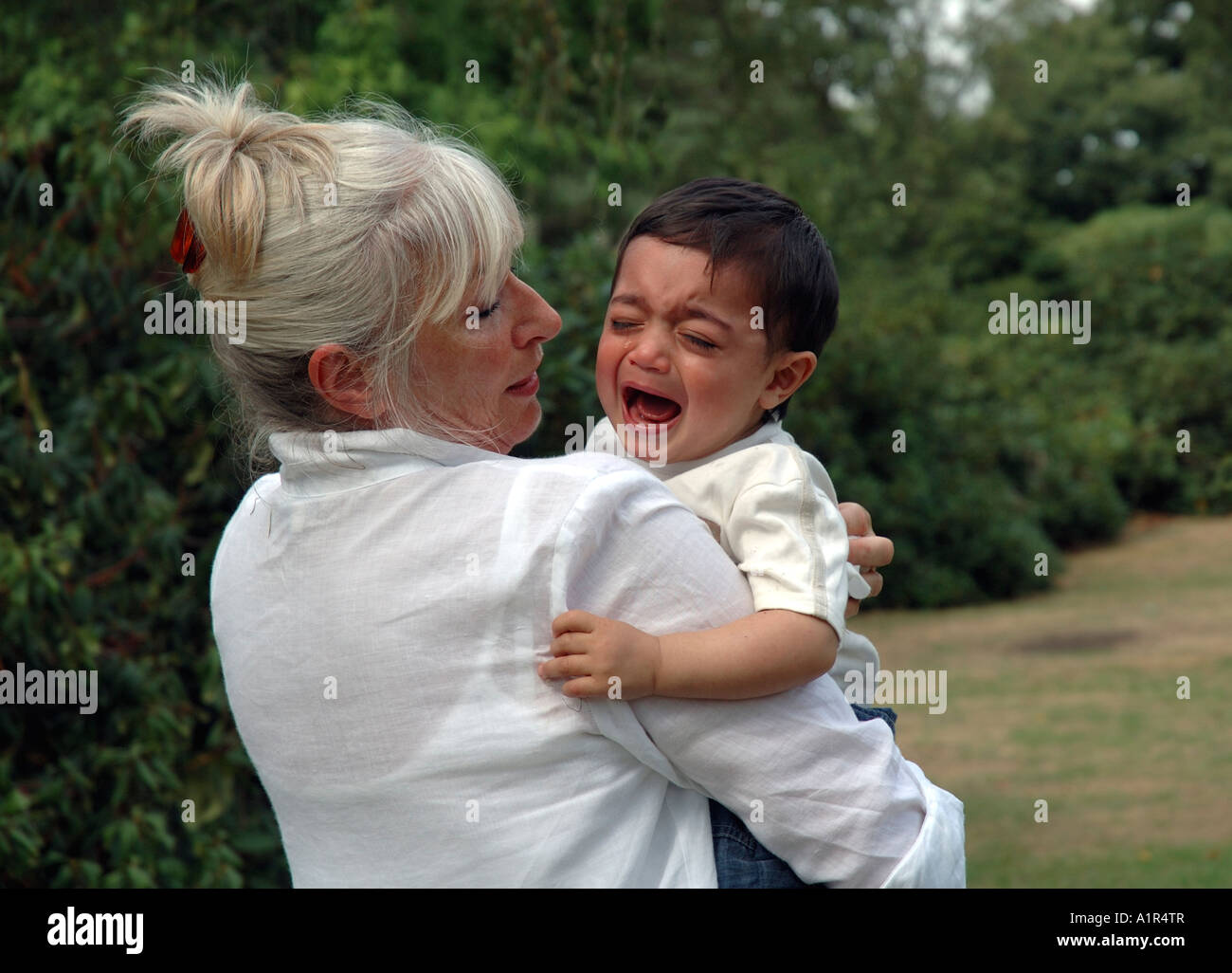 Grandmother comforting crying toddler Stock Photo - Alamy