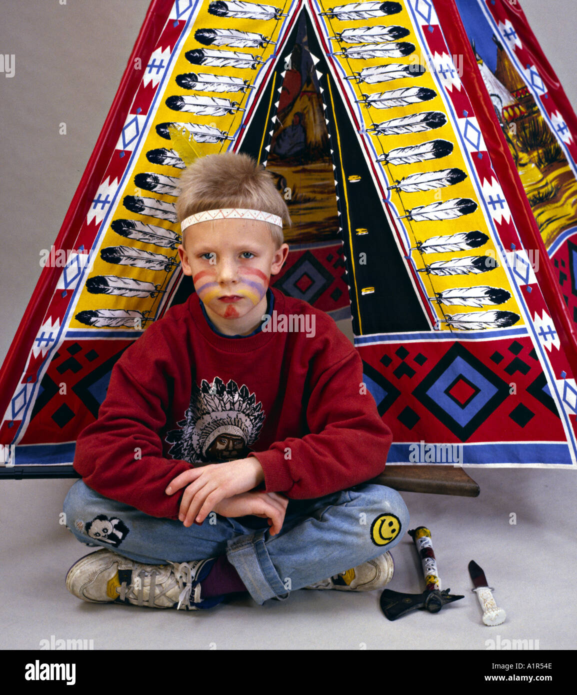 boy dressed up as Red Indian sitting in front of a wigwam for children ...