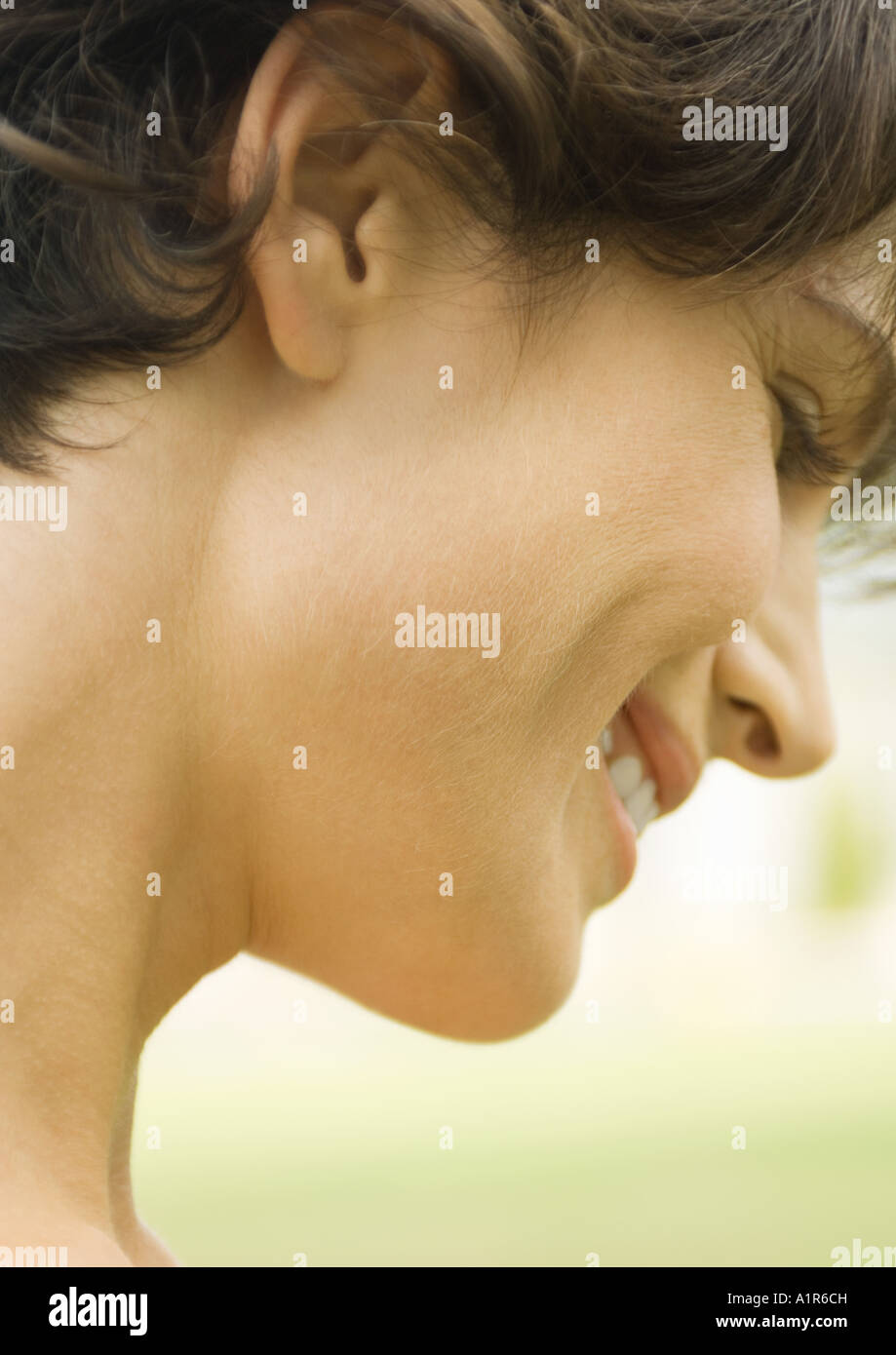 Woman smiling and looking down, close up side view of face Stock Photo ...