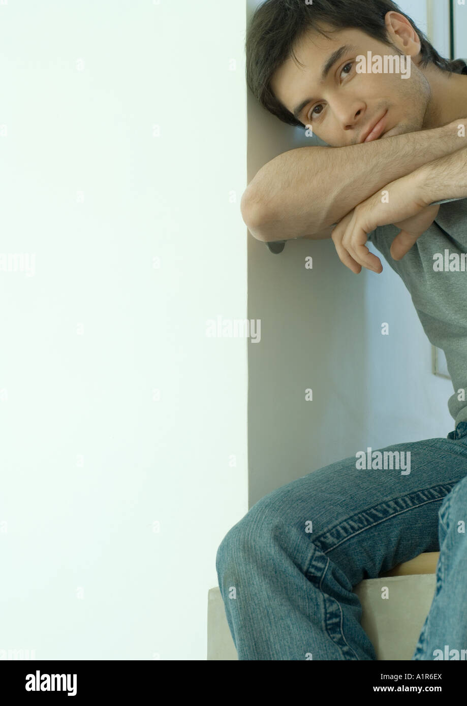 Man sitting, leaning on folded arms Stock Photo - Alamy