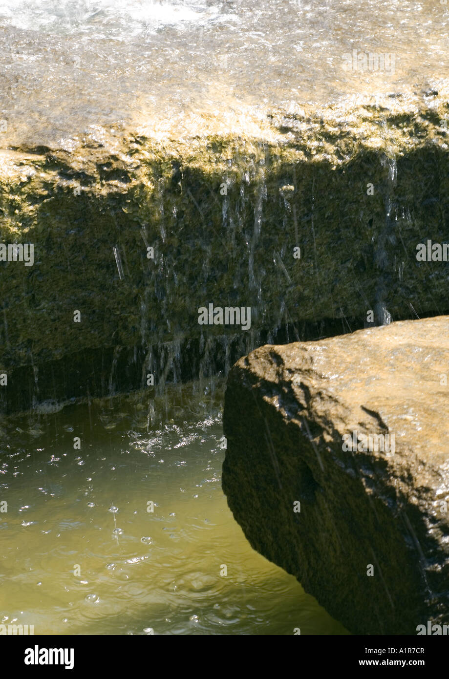 Water flowing over edge of stone block Stock Photo - Alamy