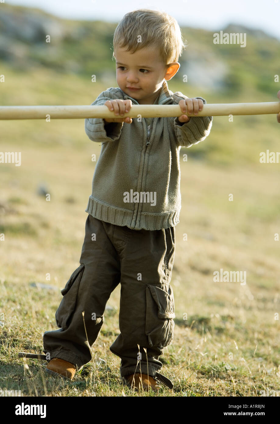 Child holding on to wooden stick Stock Photo - Alamy