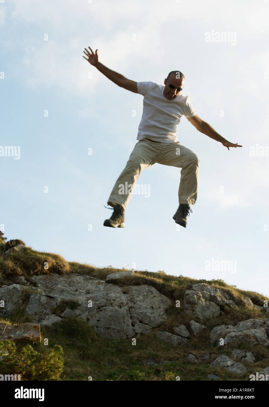 Man jumping in rocky landscape Stock Photo - Alamy