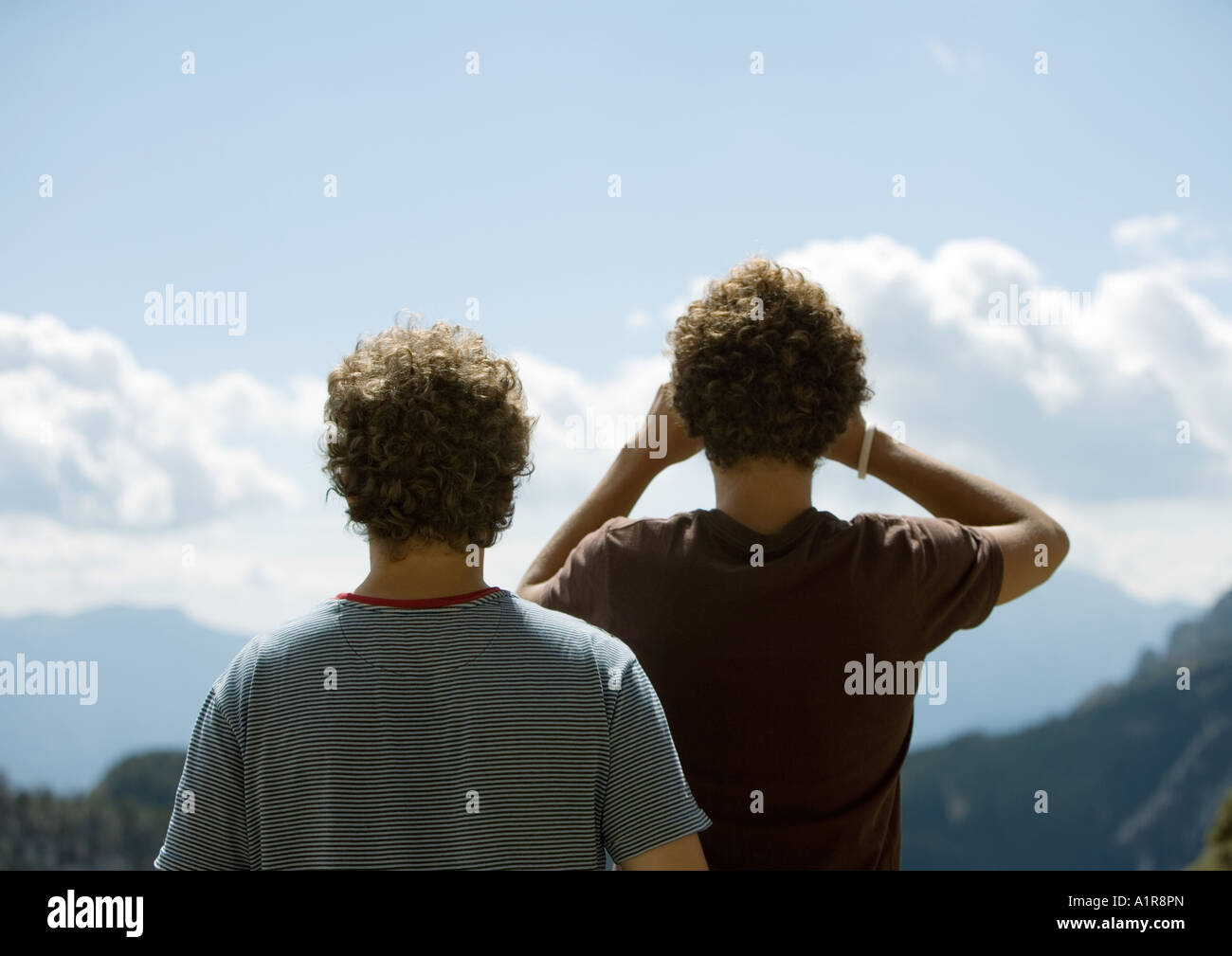 Two young men looking at mountain view with binoculars, rear view Stock ...