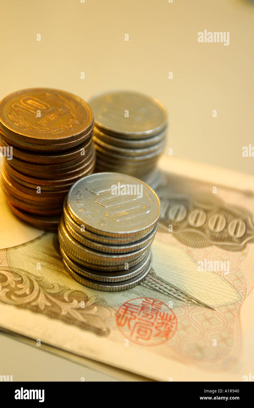 Japanese coins on dollar notes blurred Stock Photo - Alamy