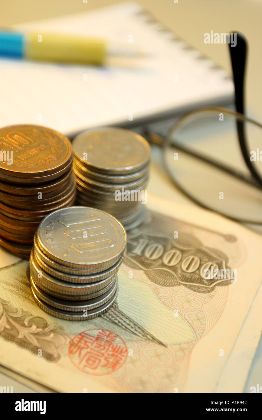 Japanese coins on dollar notes blurred Stock Photo - Alamy